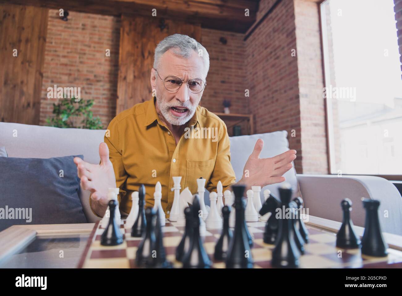 Photo of angry impressed mature man play chess wear spectacles yellow ...
