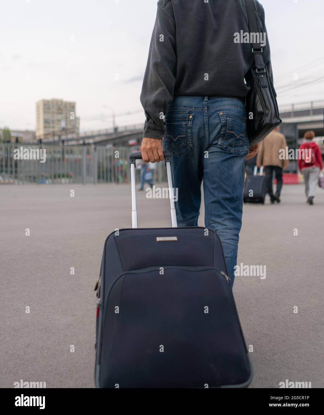 the tourist rolling the big travel bag on the trains station in the ...