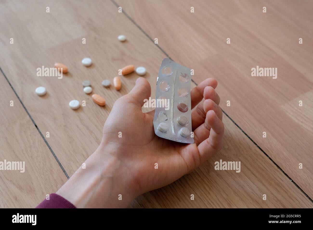 the person lying on the floor, hand with pills, medicine overdose Stock ...