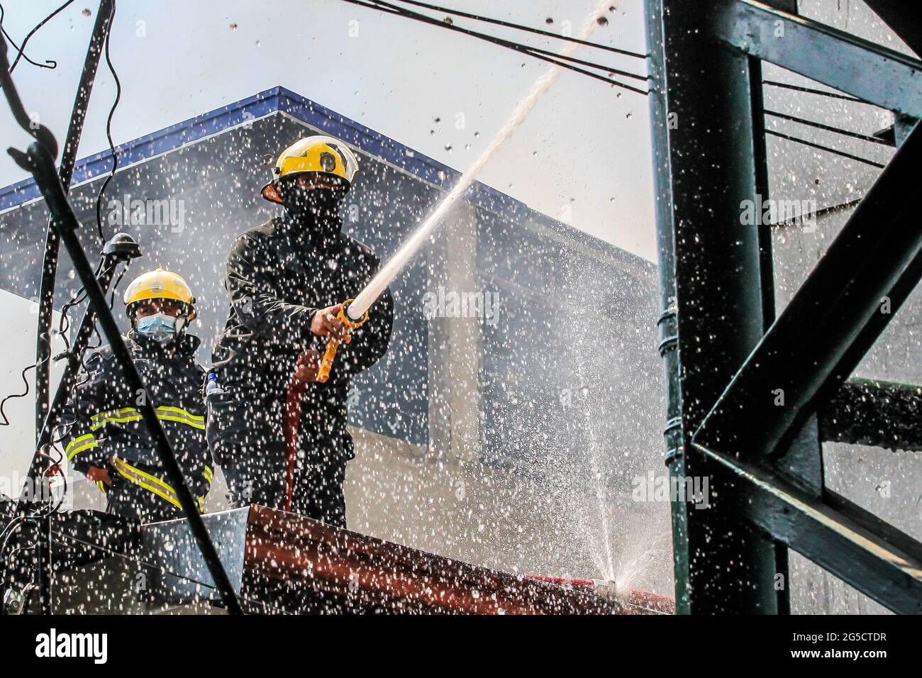 Quezon City. 26th June, 2021. Firefighters try to put out a fire at a ...