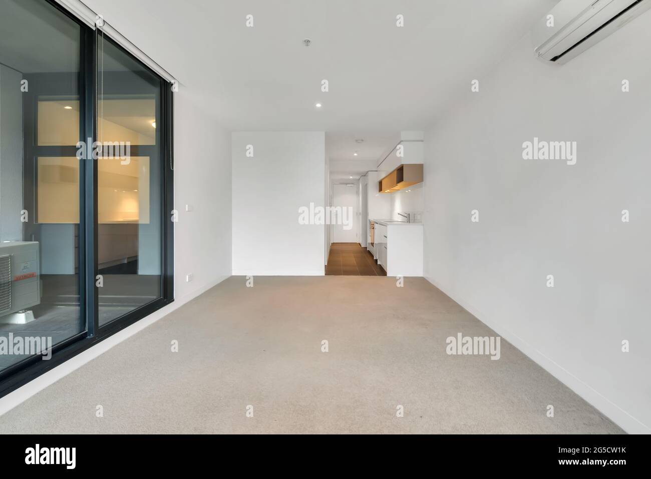 Empty kitchen room with laminate flooring and white walls Stock Photo ...