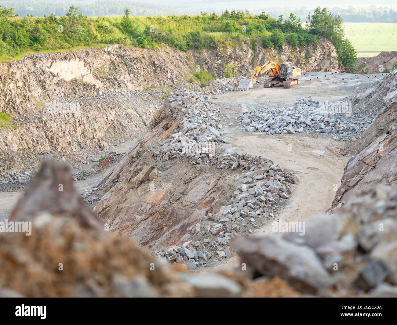 Excavator during earthmoving work at open-pit mining on gravel quarry ...