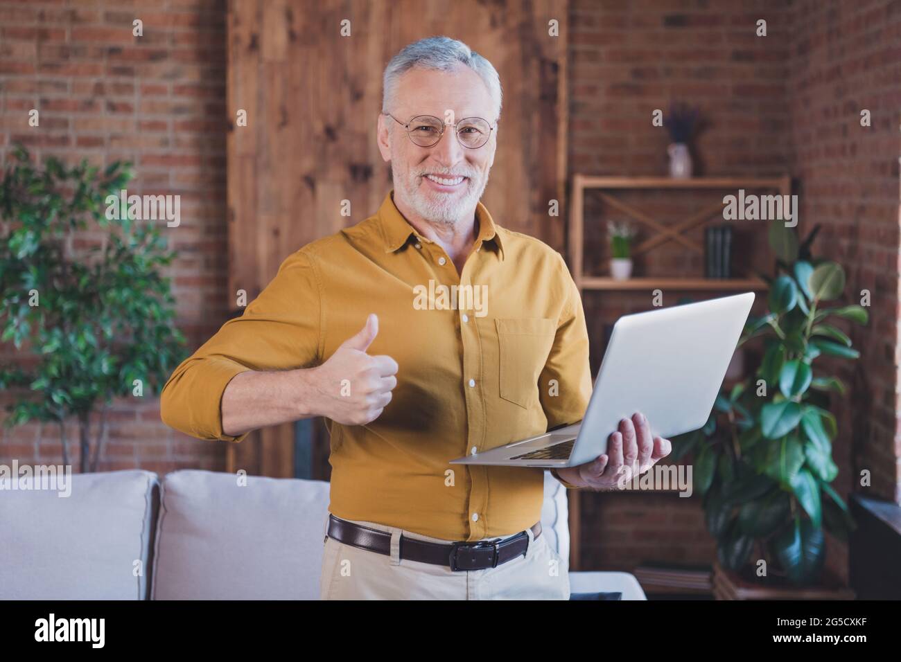 Portrait of handsome positive man hold laptop toothy smile look camera ...