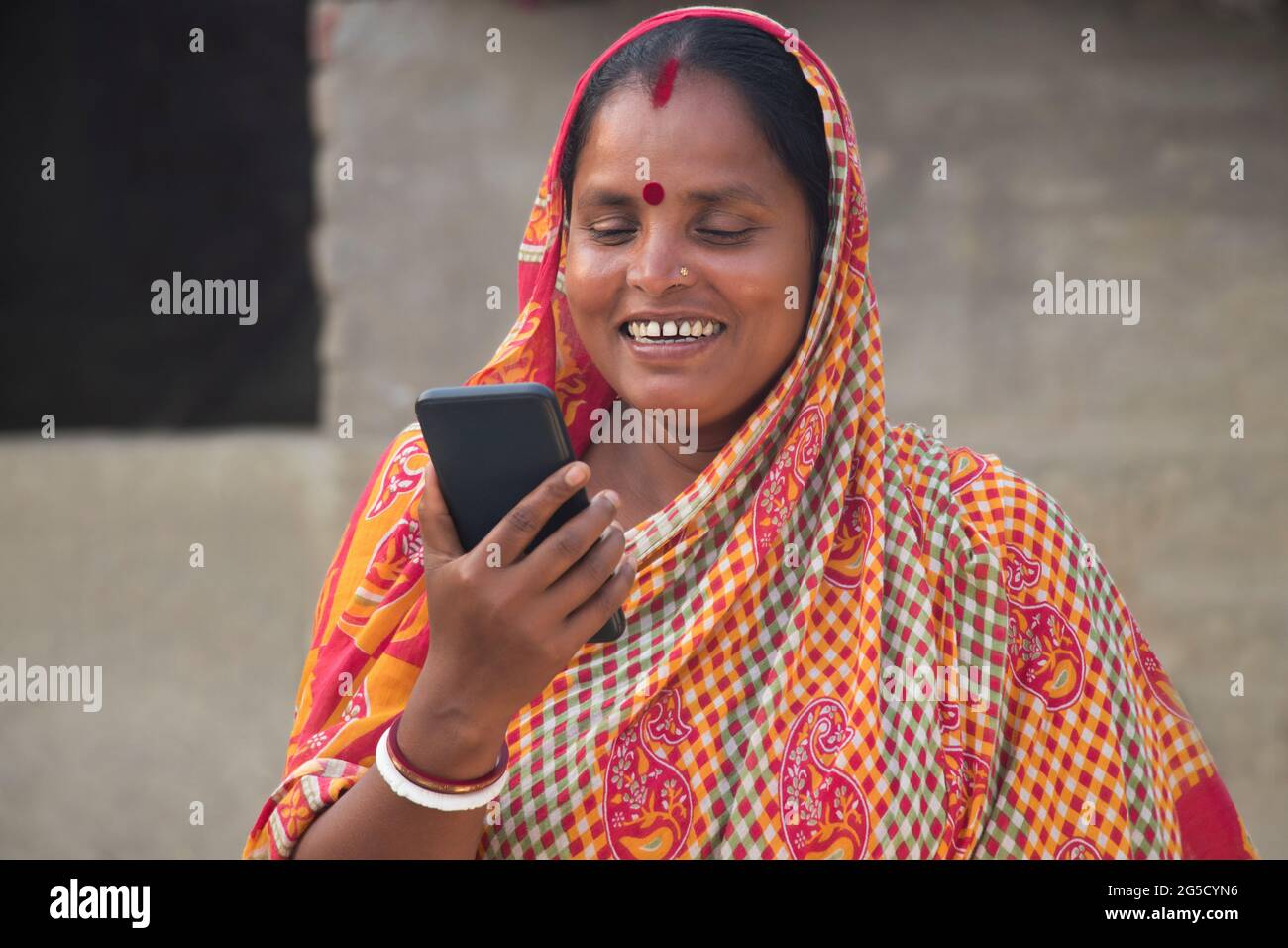Indian Rural Woman Holding mobile phone Stock Photo - Alamy