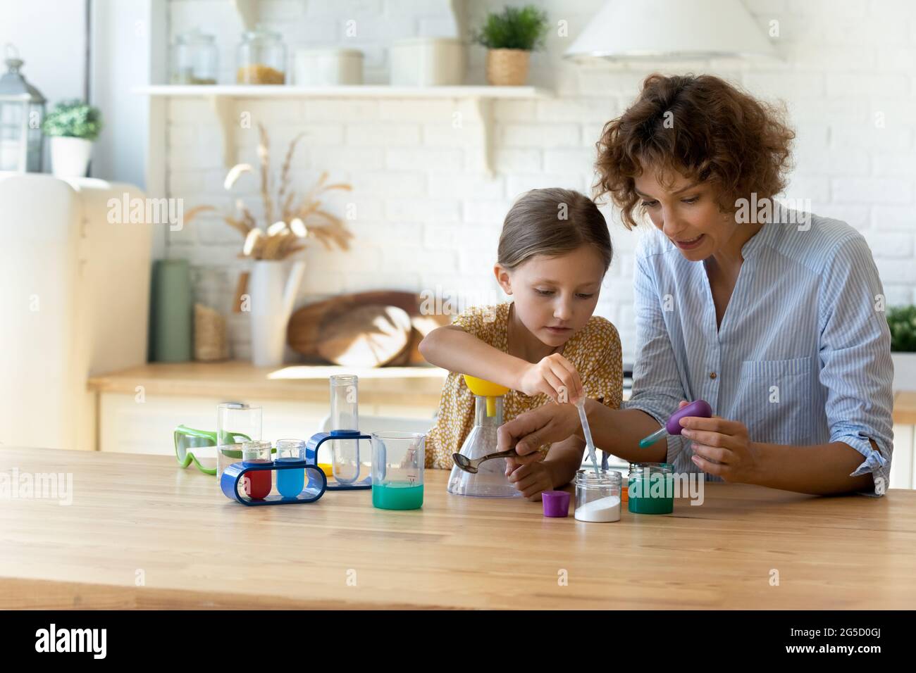Concentrated small kid doing experiments with mum at home Stock Photo ...