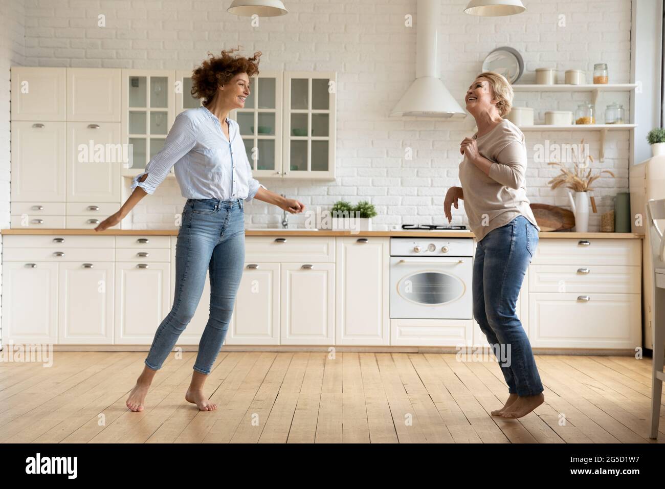 Happy female family dancing together in modern kitchen Stock Photo - Alamy