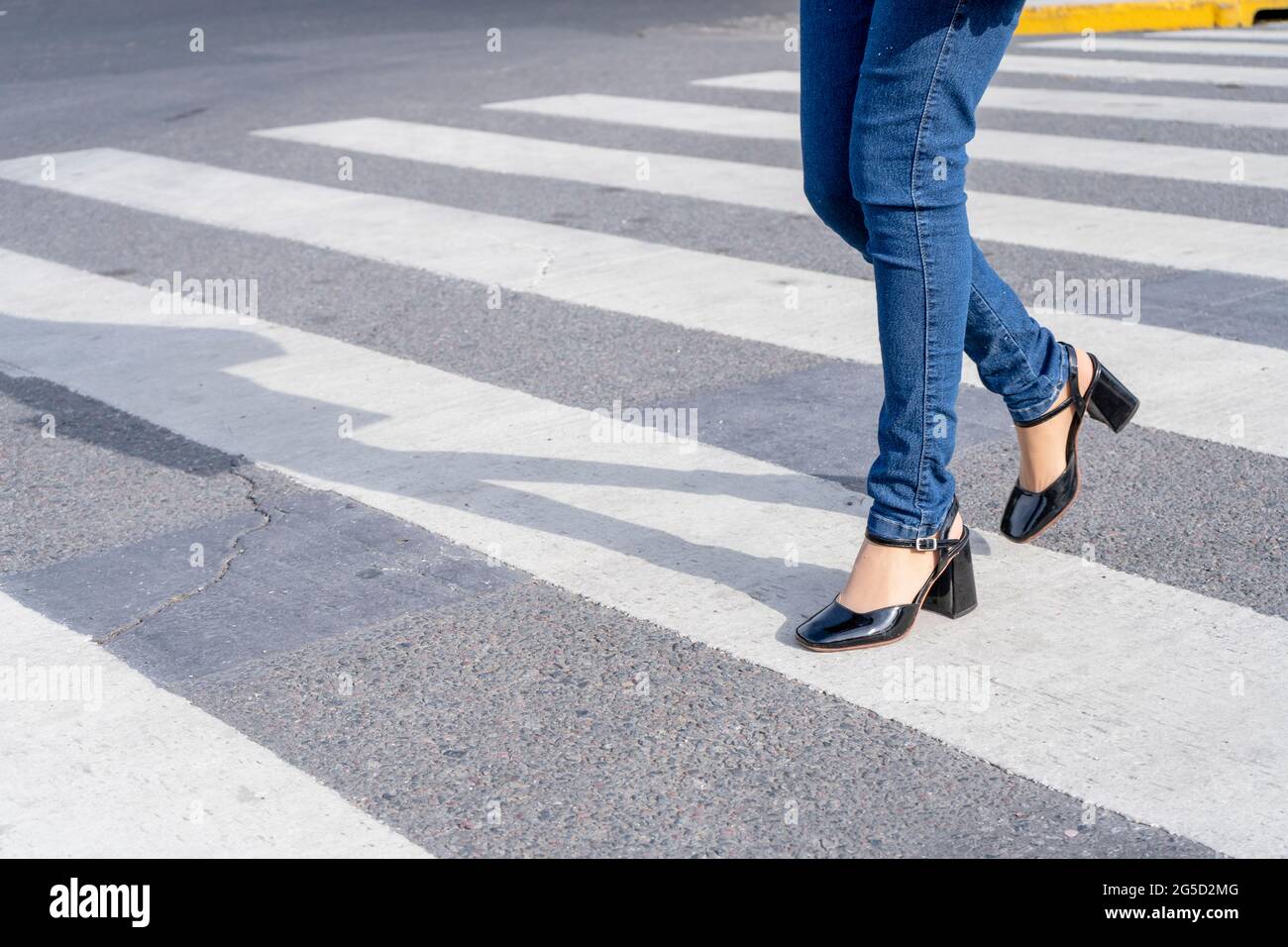 Woman's legs with shoes and pants crossing a street on the pedestrian ...