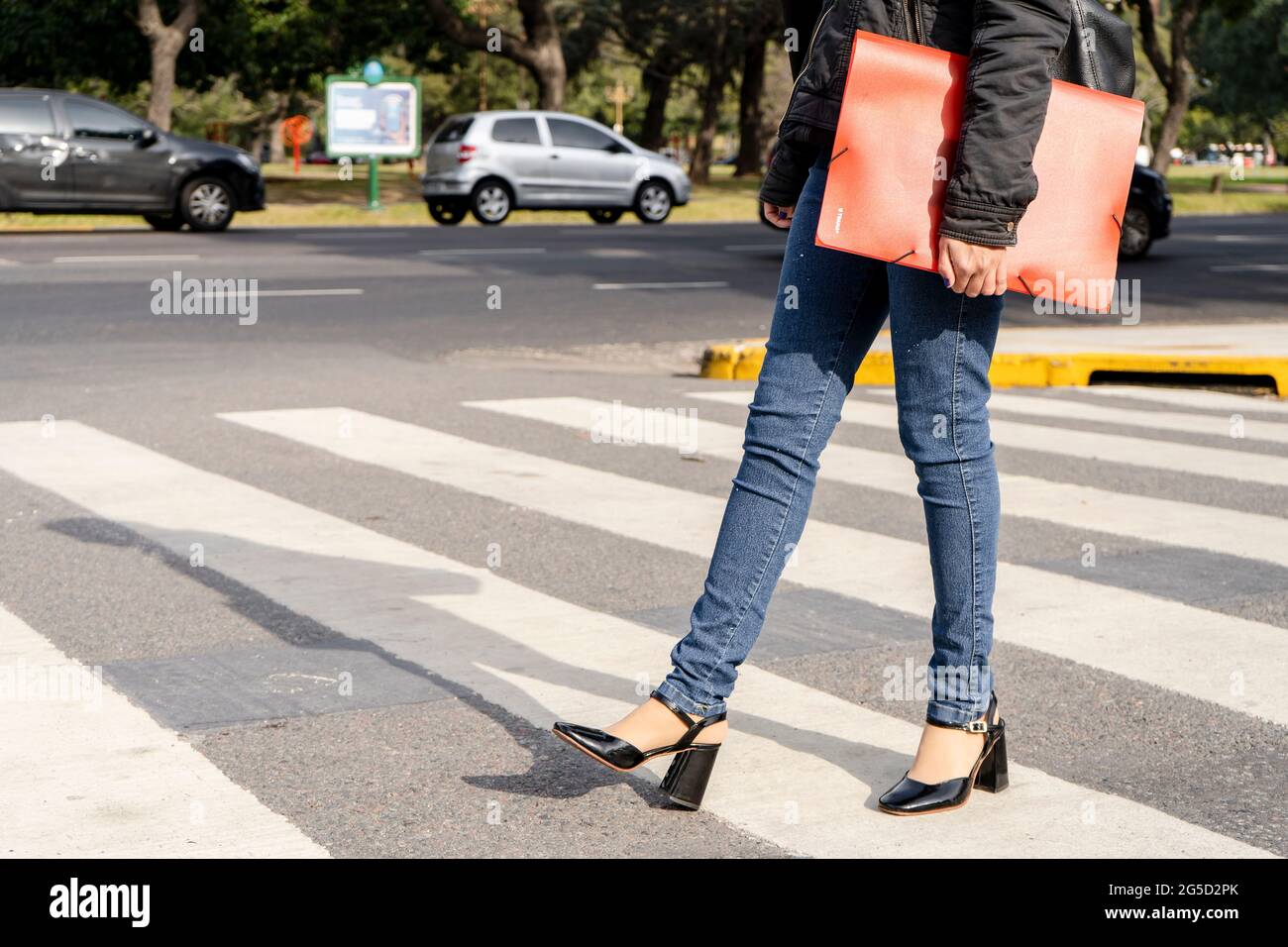 Woman's legs with shoes and pants crossing a street on the pedestrian ...