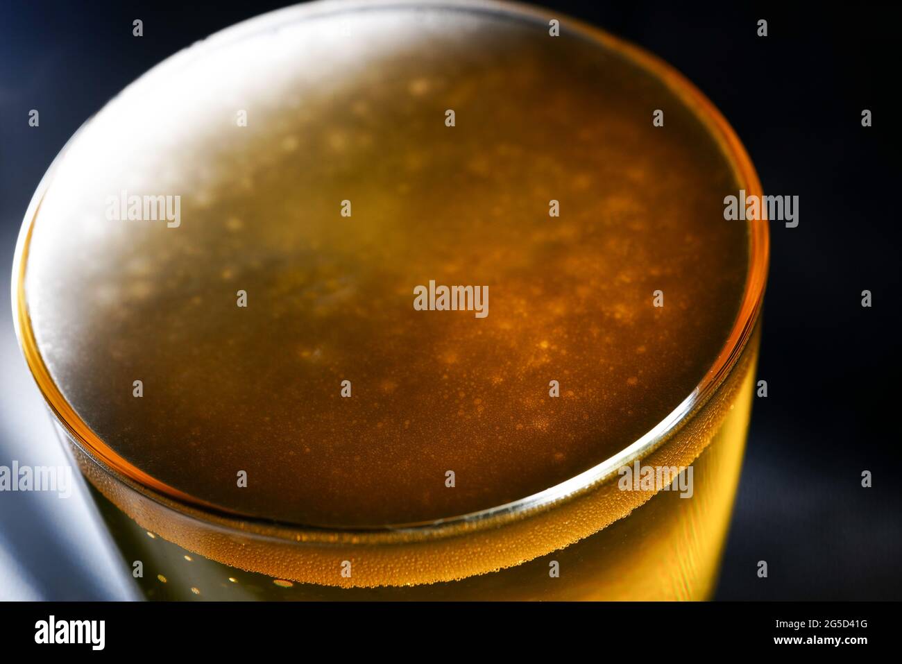 Glass of cold drink in yellow on black background Stock Photo - Alamy