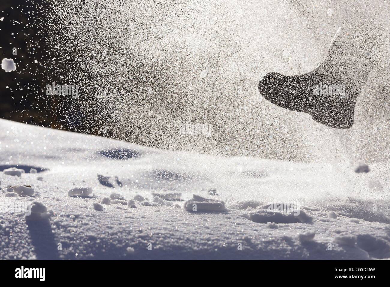 Snow in the air hit by a boot Stock Photo - Alamy