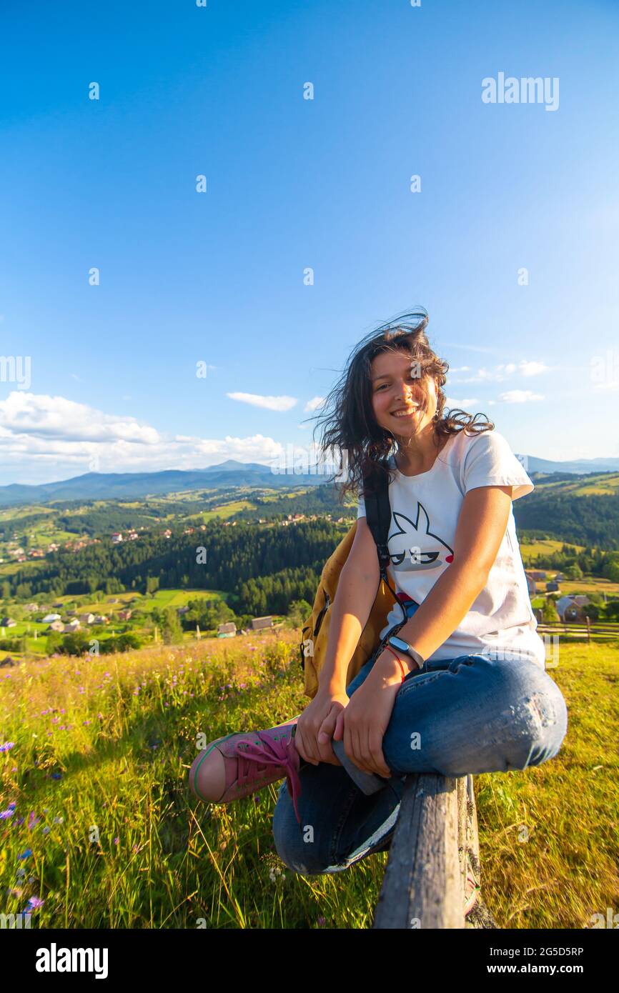 Happy gorgeous girl enjoy hills view sitting in flower field on the ...