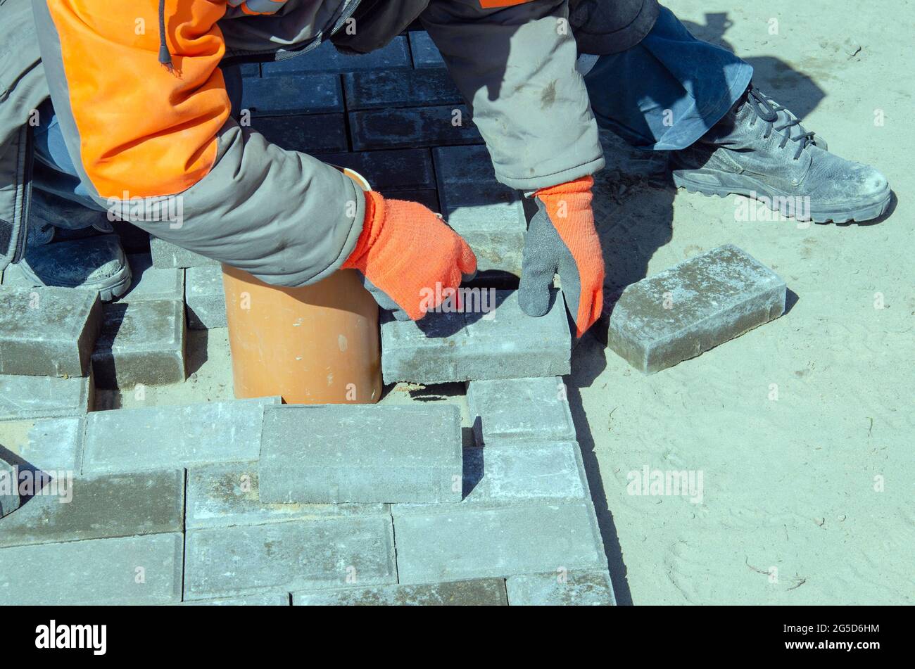 Construction of pavement near the house. Bricklayer places concrete ...