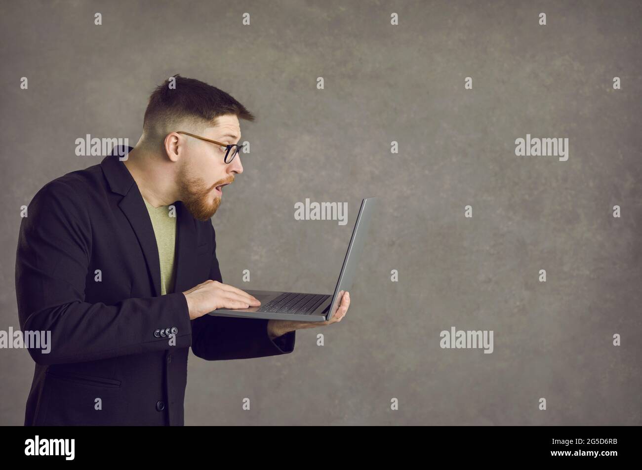 Shocked young man looking at the notification on the screen of his ...
