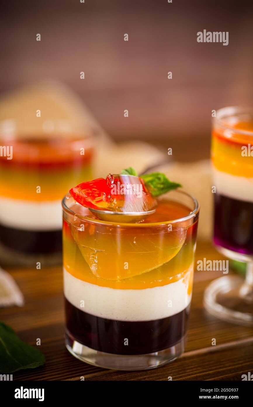 lot of colored sweet fruit jelly in a glass on a wooden table Stock ...