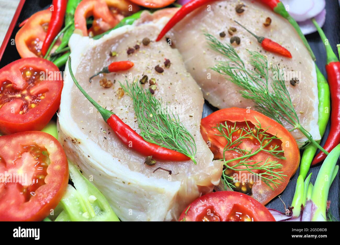 Meat on a light background, vegetables and spices, onions, red and ...