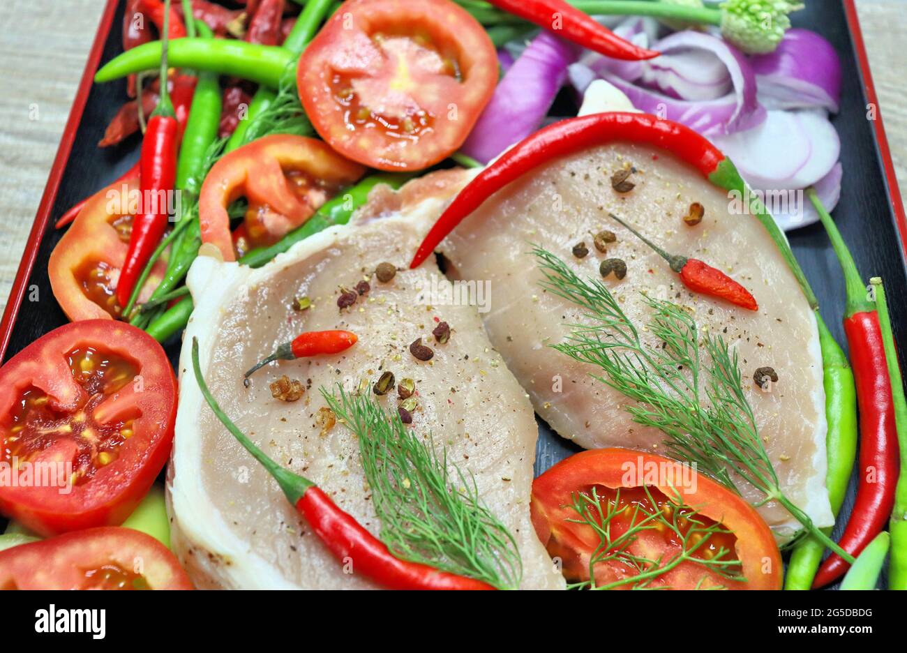 Meat on a light background, vegetables and spices, onions, red and ...