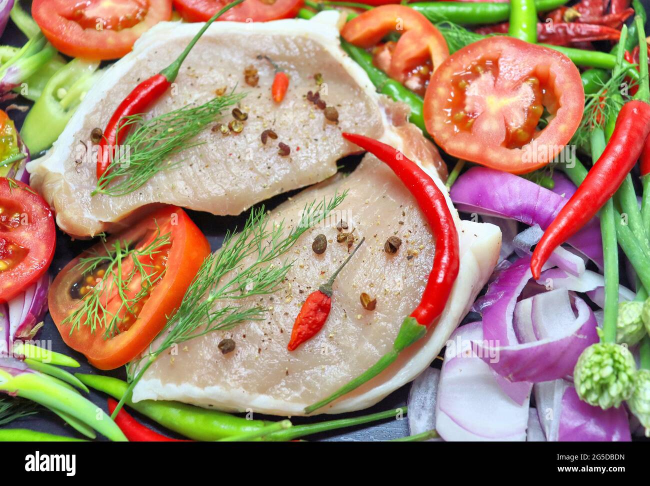 Meat on a light background, vegetables and spices, onions, red and ...