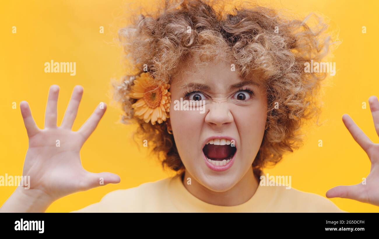 Beautiful young girl with a flower on her ear trying to listen to ...