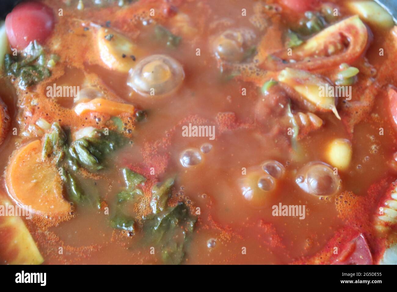 Vegetable stew, red and green ingredients in a skillet over the fire ...