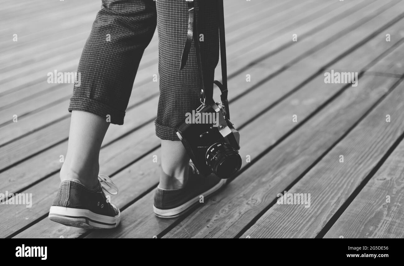Hipster look. Female legs in sneakers walking a wooden surface and a ...