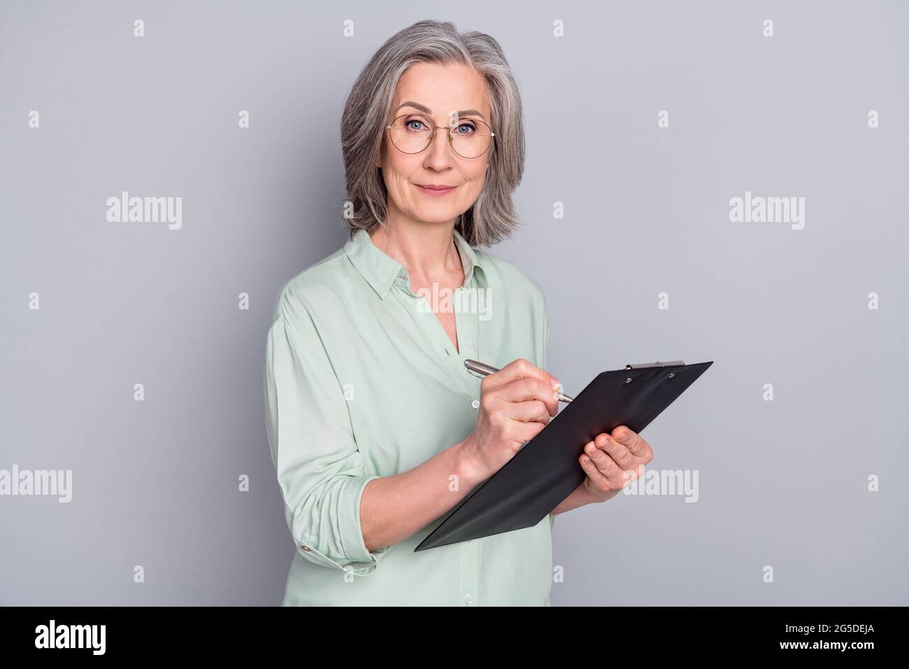 Photo of happy good mood beautiful confident woman in glasses writing ...