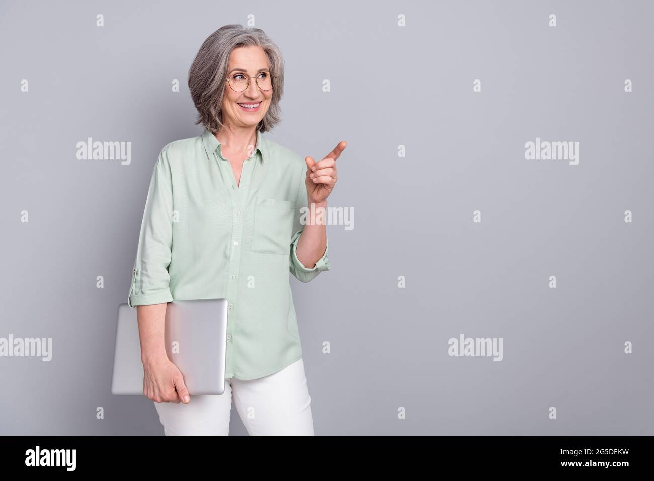 Photo of happy beautiful smiling mature woman point finger copyspace ...