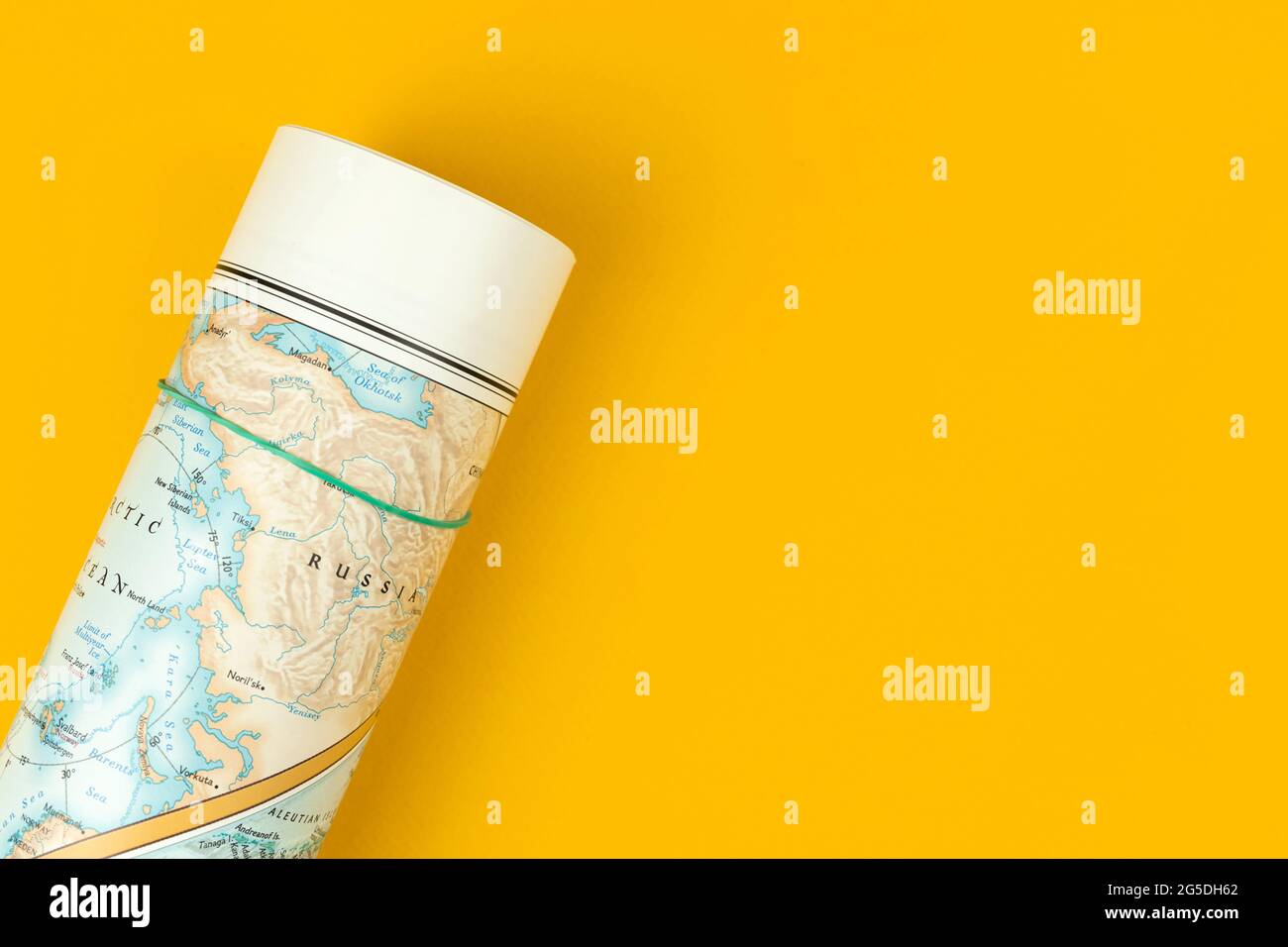 World map on the table, flat lay composition and yellow desktop ...