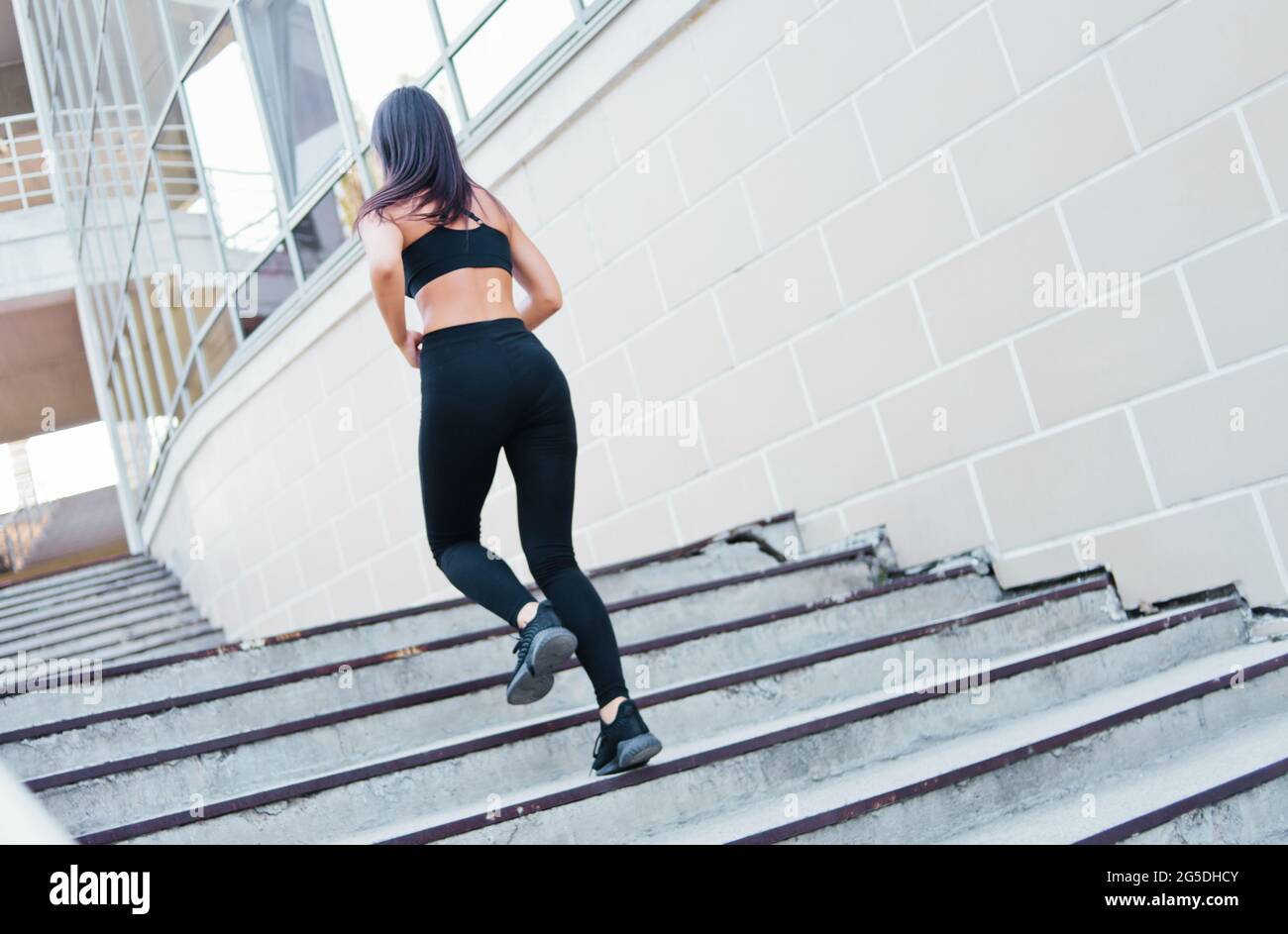 Attractive woman running up on stairs outdoors. Back view Stock Photo ...