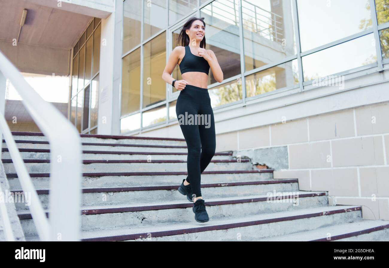 Attractive woman running down on stairs outdoors Stock Photo - Alamy