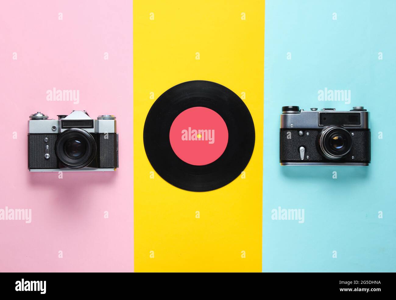 Retro still life, 70s. Vinyl record and two film camera on pastel ...