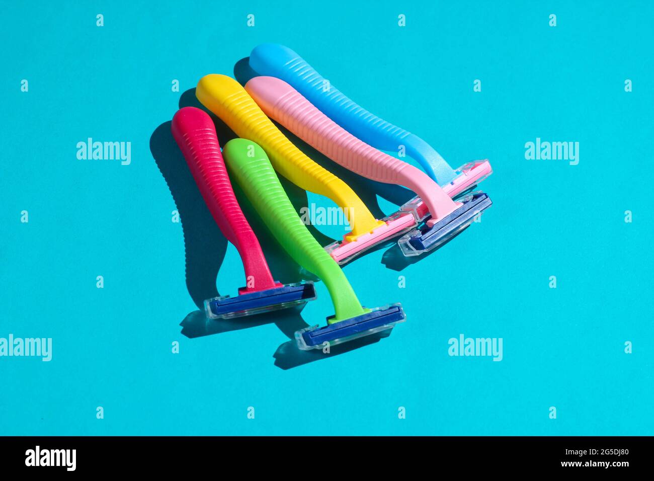 Beauty and fashion pop art concept. Many colored plastic razors on blue ...