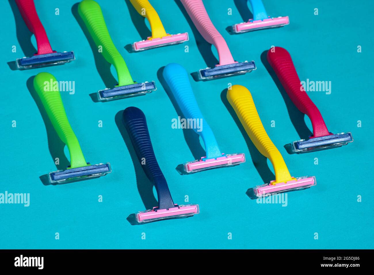 Beauty and fashion pop art concept. Many colored plastic razors on blue ...