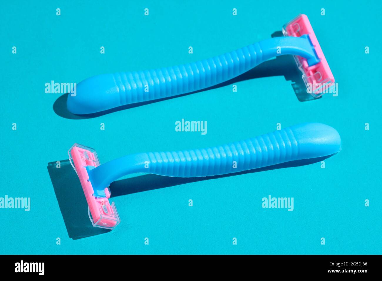 Two plastic razors on blue background. Minimalistic beauty and fashion ...