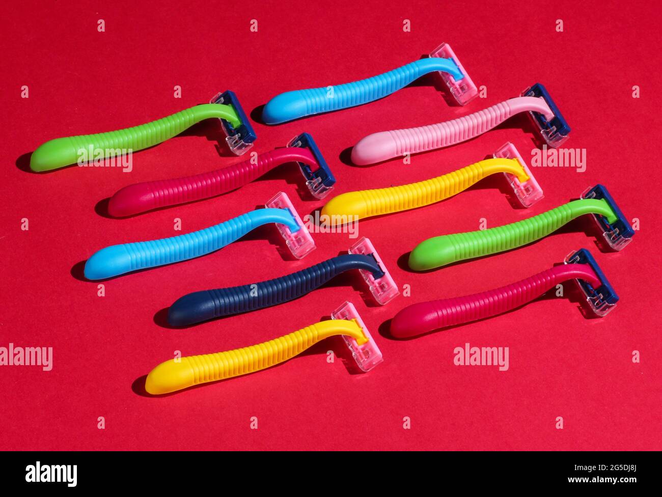 Beauty and fashion pop art concept. Many colored plastic razors on red ...
