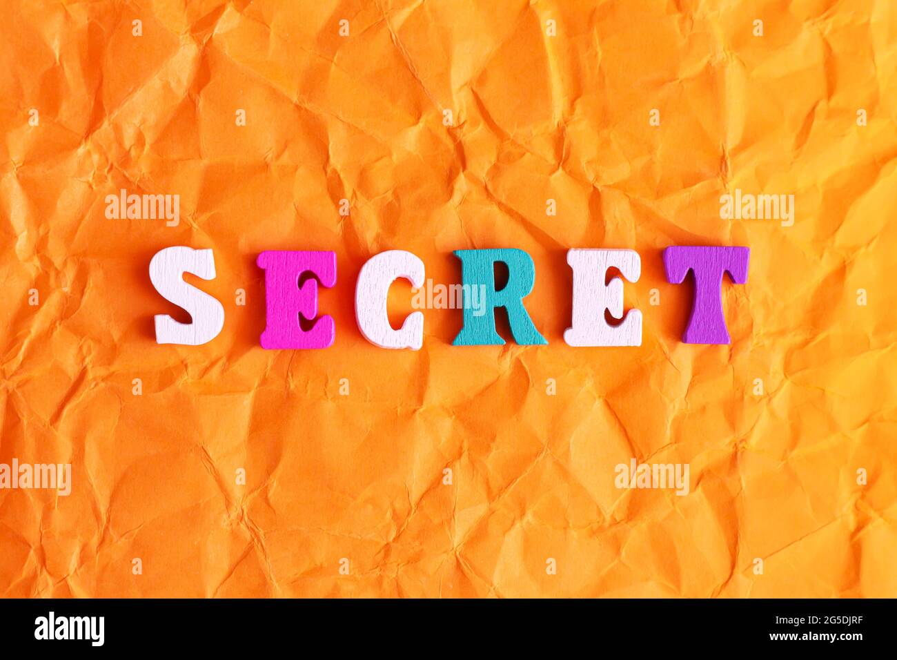 Colorful text SECRET on orange crumpled paper background Stock Photo ...
