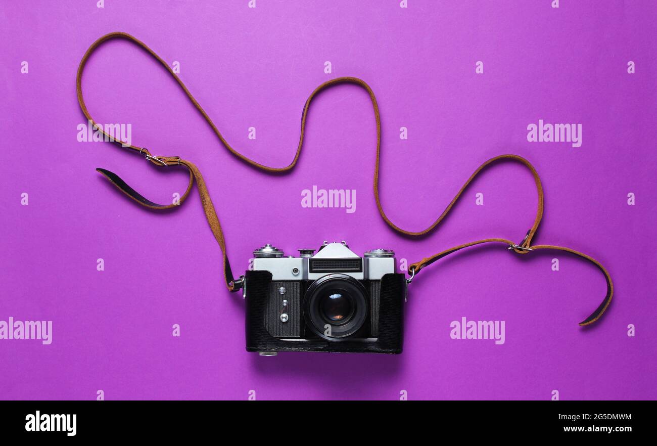 Vintage retro film camera in leather cover with strap on purple ...