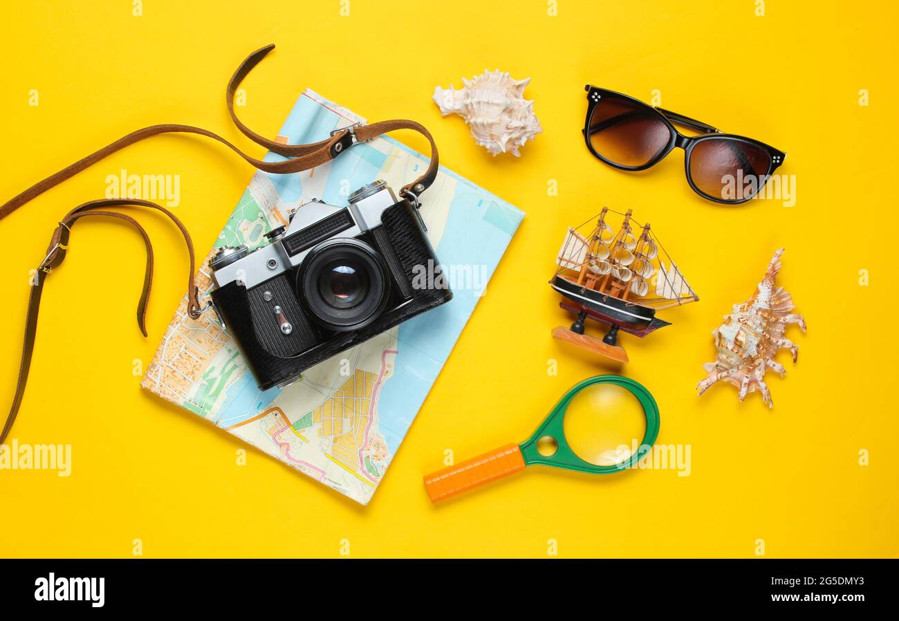 Flat lay travel accessories and retro camera on yellow background. Summer beach background. Top ...