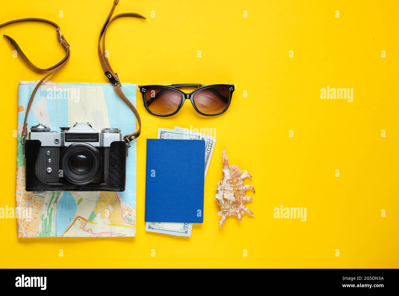 Flat lay travel accessories and retro camera on yellow background. Summer beach background. Top ...