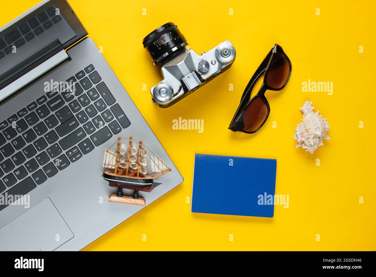 Flat lay travel accessories and retro camera on yellow background with ...