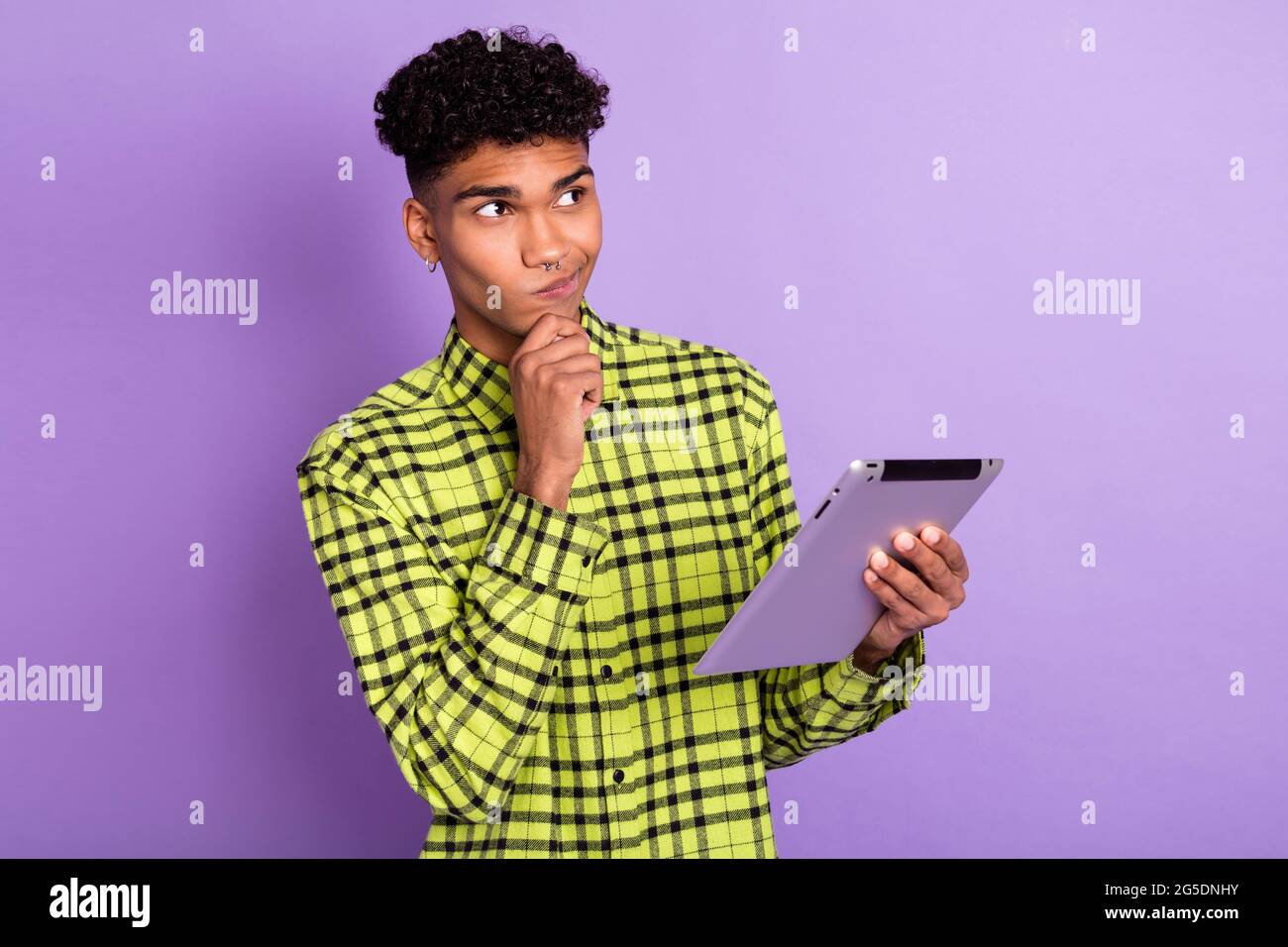 Photo portrait of guy thoughtful looking empty space keeping tablet ...