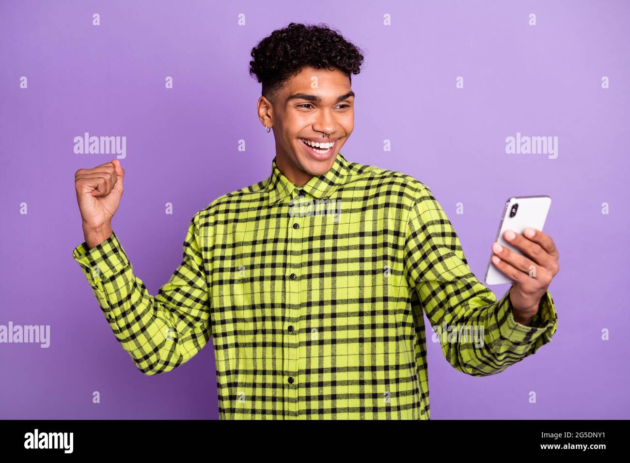Portrait of attractive cheerful lucky guy using gadget celebrating ...