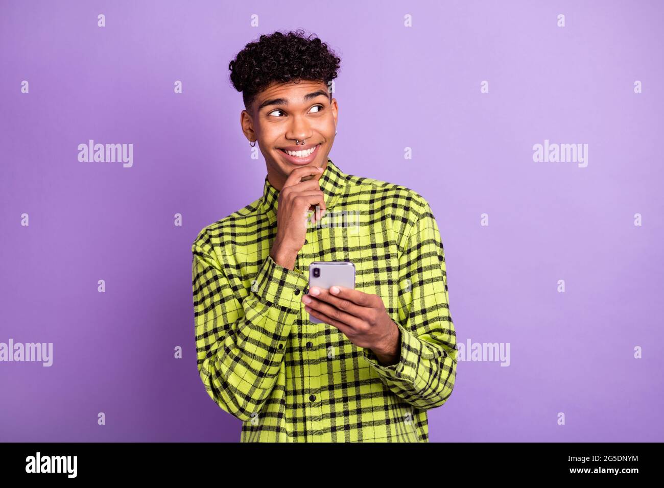 Photo of minded dreamy afro american man hold phone look empty space ...