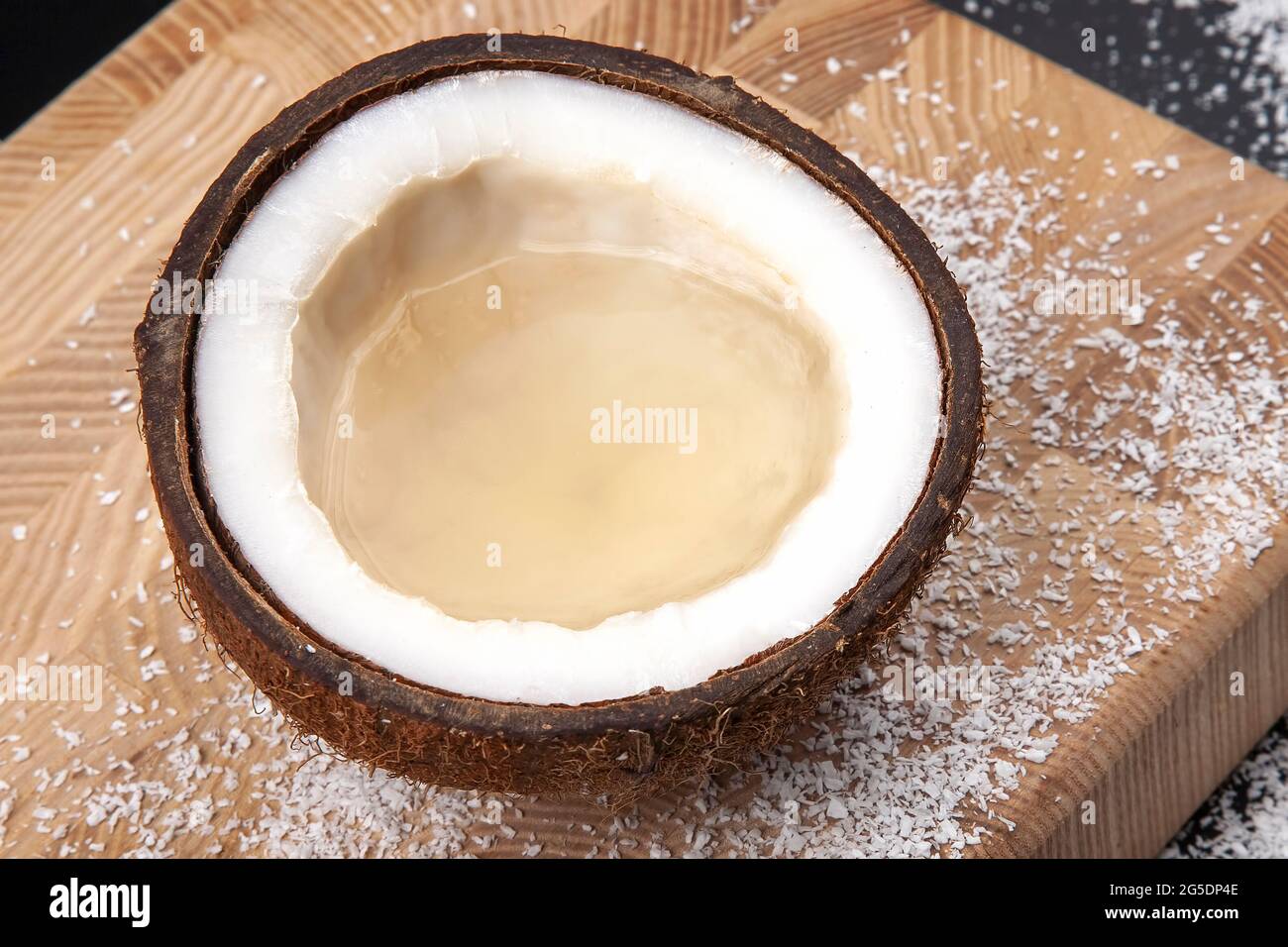 cut fresh coconut with real coconut milk on background of coconut ...