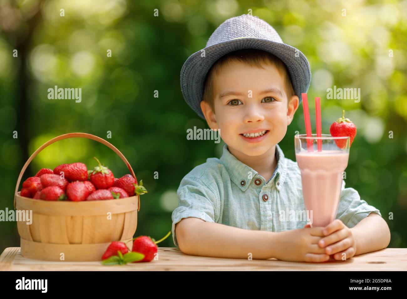little boy holding glass of strawberry milkshake outdoors Stock Photo ...