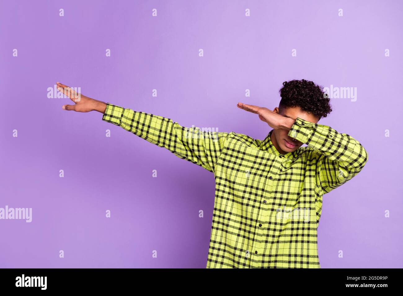 Portrait of attractive wavy-haired guy dancing showing dab sign move ...