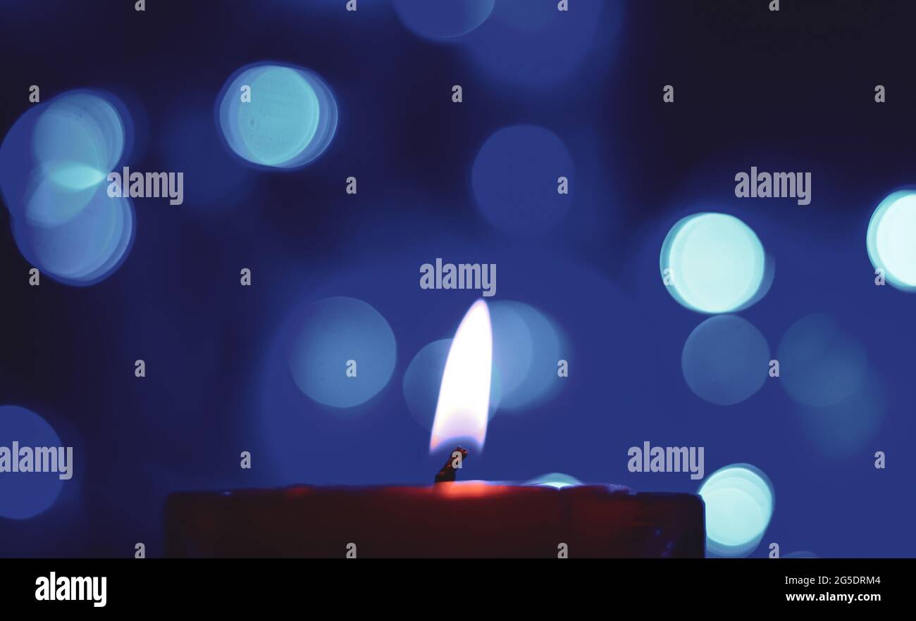 Candle lights in darkness with colorful light effects and bokeh for ...