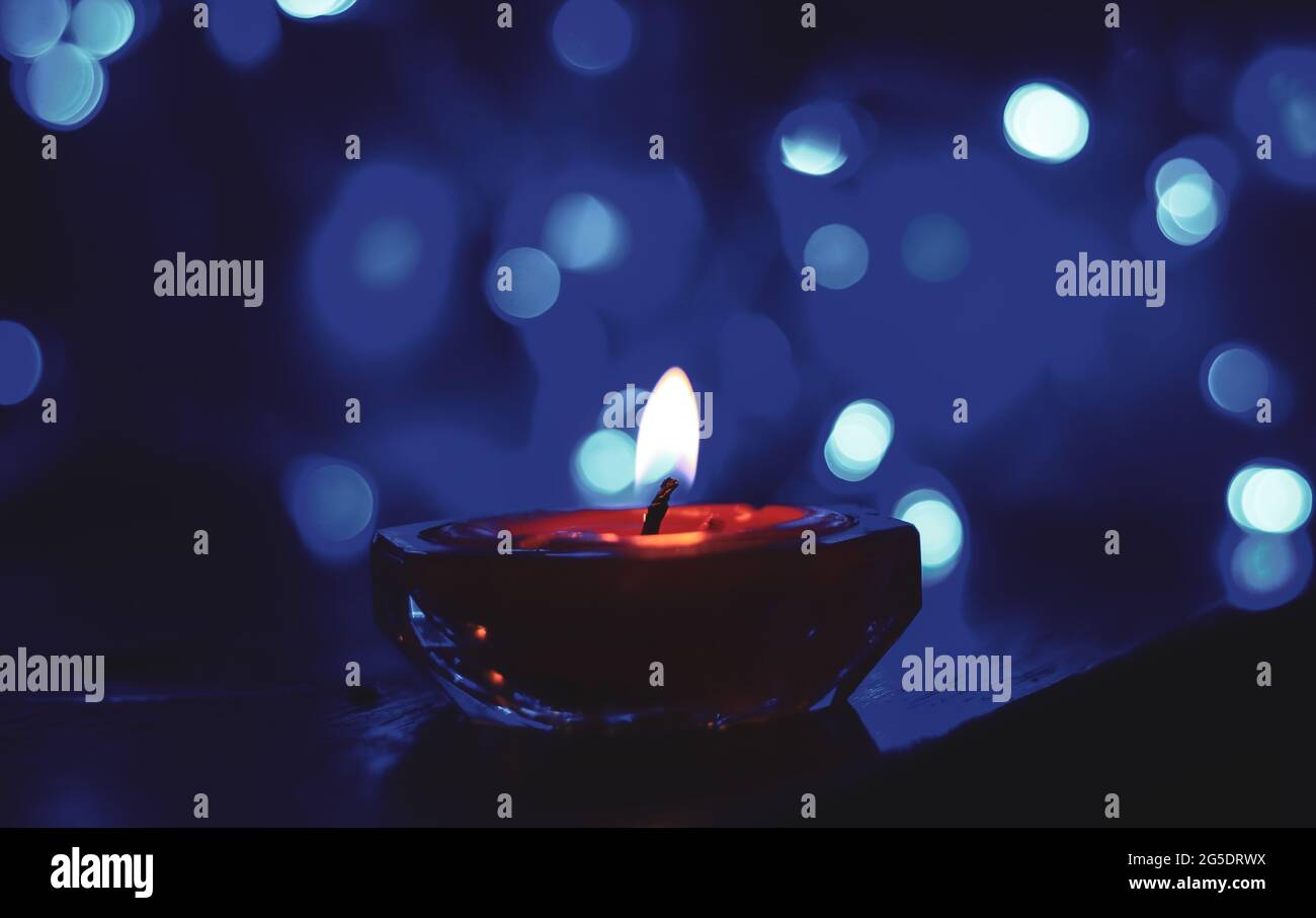 Candle lights in darkness with colorful light effects and bokeh for ...