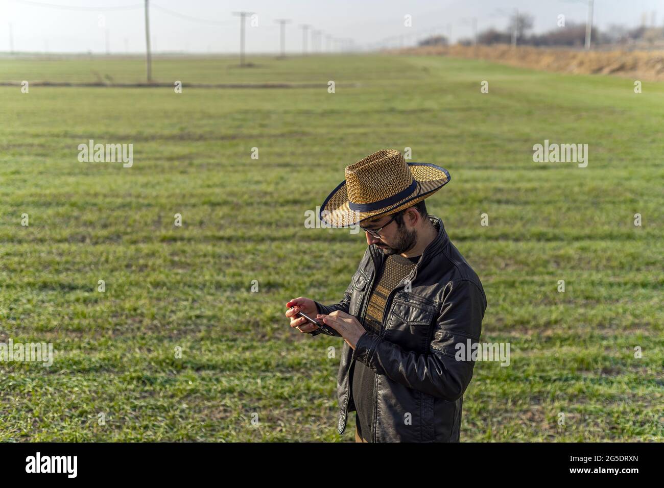 Young Turkish farmer using the phone for monitoring the field - smart ...