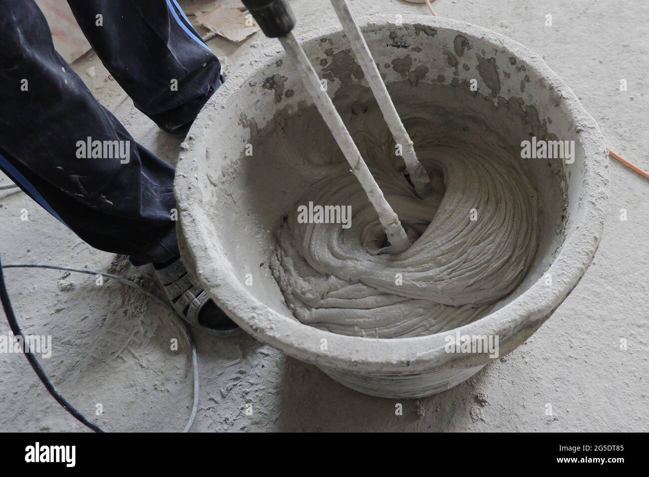 the builder mixes the construction mixture in a container for guiding ...