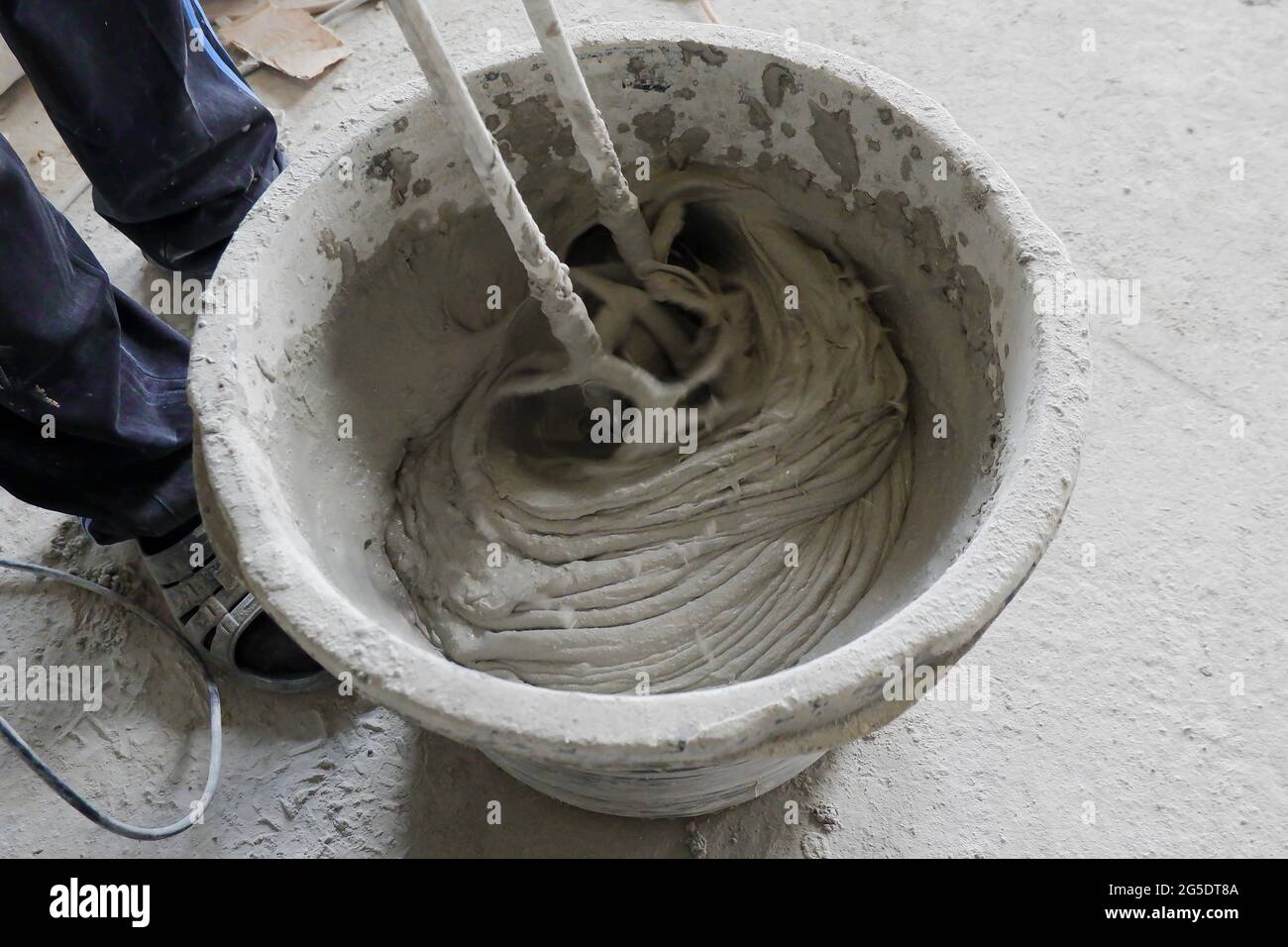 the builder mixes the construction mixture in a container for guiding ...